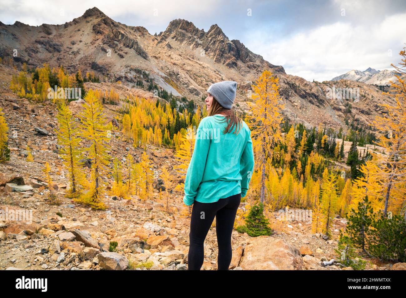 Female posing in a basin of larches in the alpine lakes wilderness ...