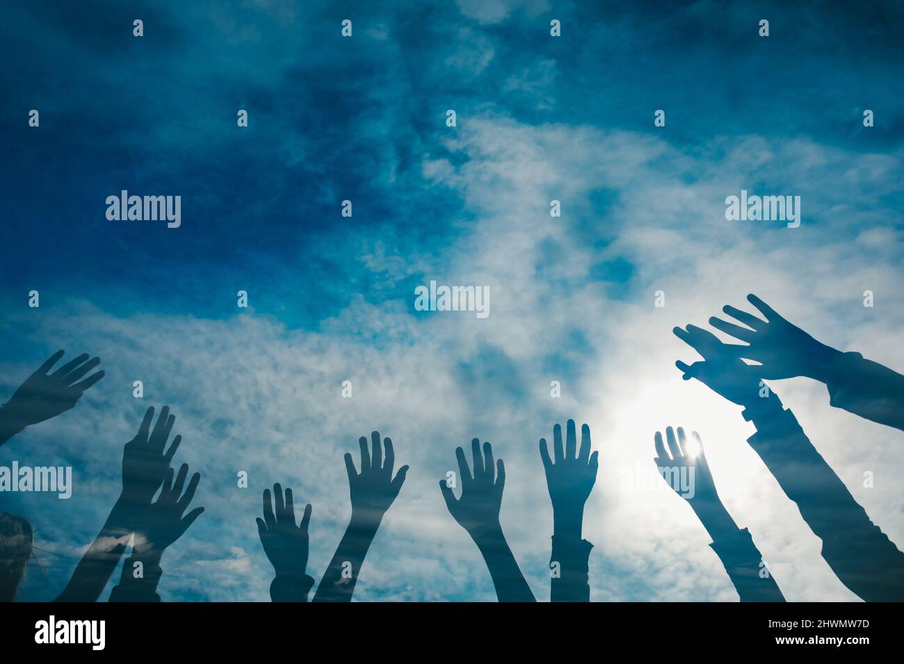 Childrens hands reaching into the blue and clouds sky Stock Photo - Alamy