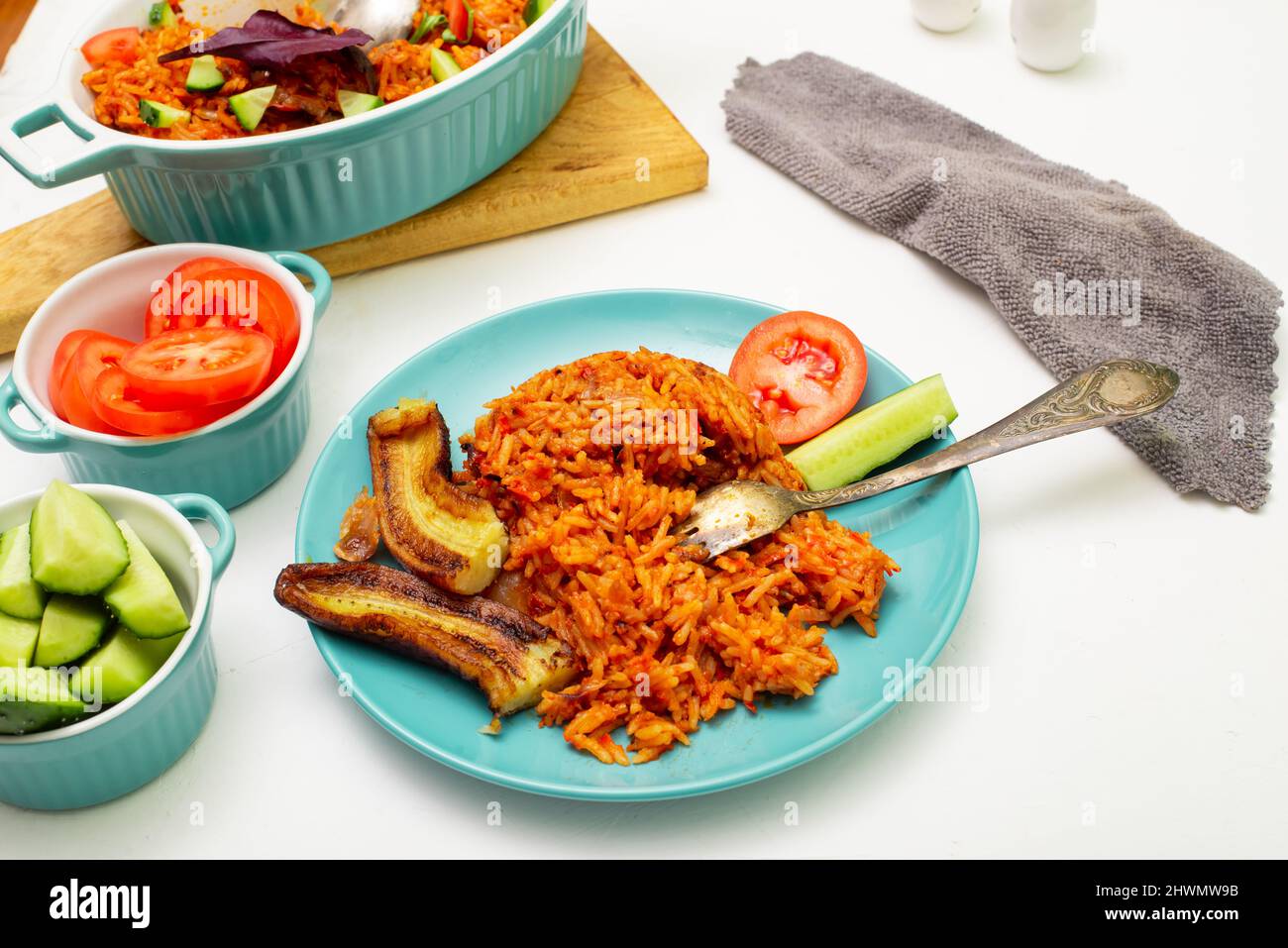 Jollof rice with fried banana on a plate. Rice with tomatoes, onions ...