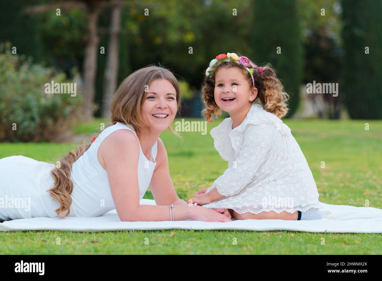 Happy Mother And Daughter Lying On The Grass In The Park Outdoors Stock