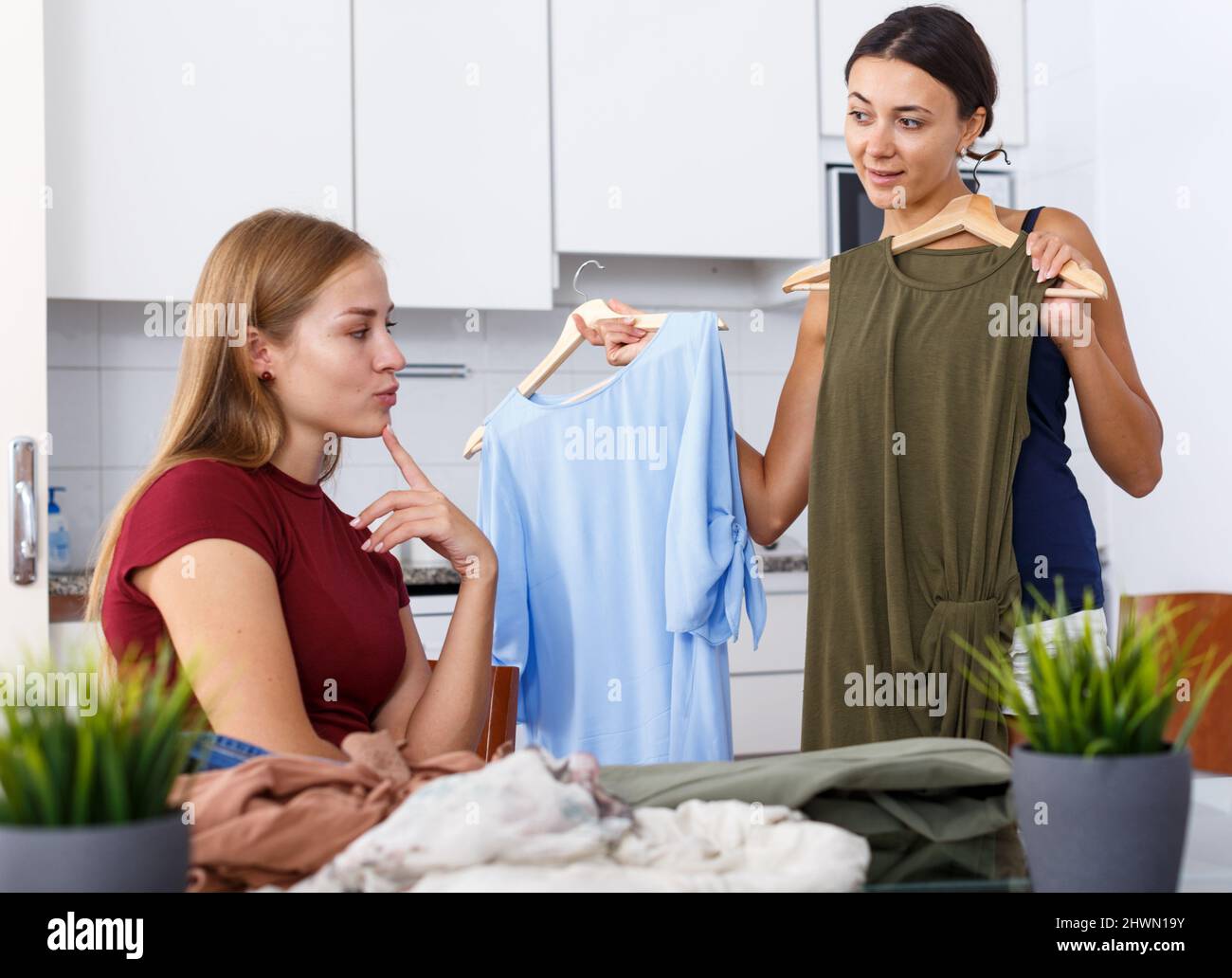 Girls talking and showing each other clothes Stock Photo - Alamy
