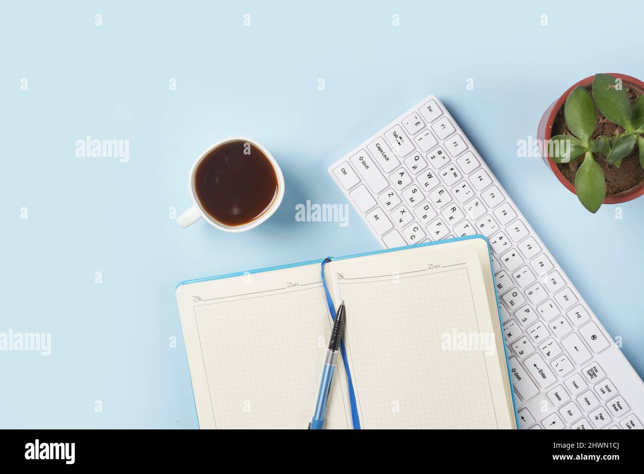 Bright office workspace. Work space with notepad, keyboard, coffee and ...