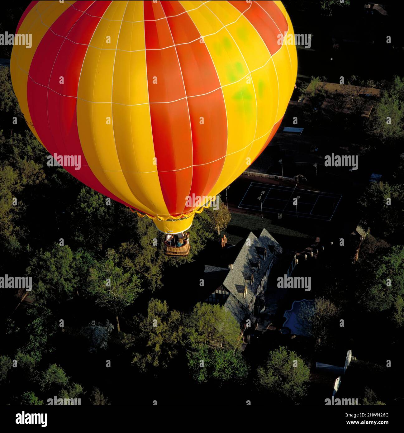 A hot air balloon floats low over a neighborhood Stock Photo - Alamy