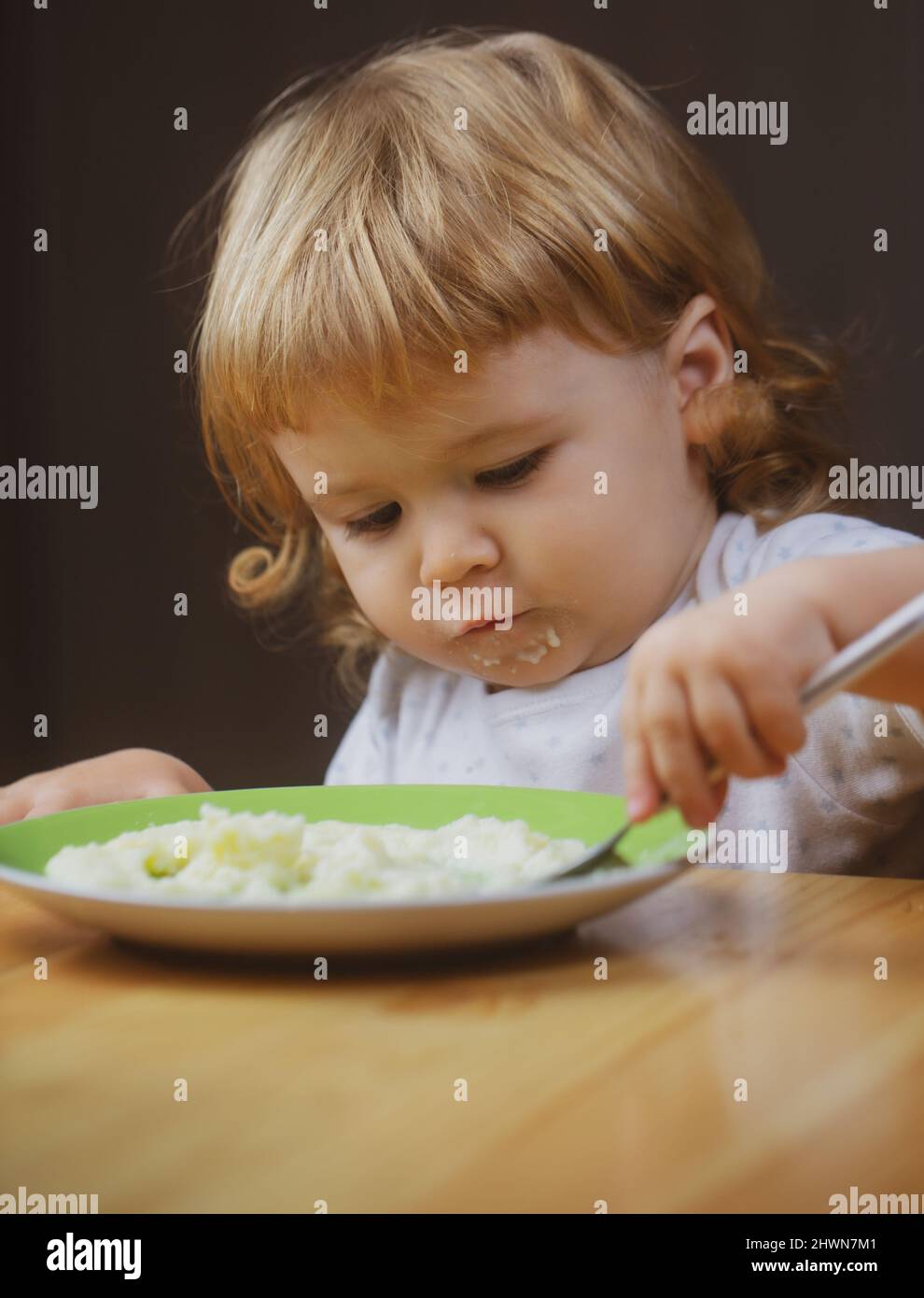 Child eating, nutrition concept. Cute baby face with a spoon and a ...