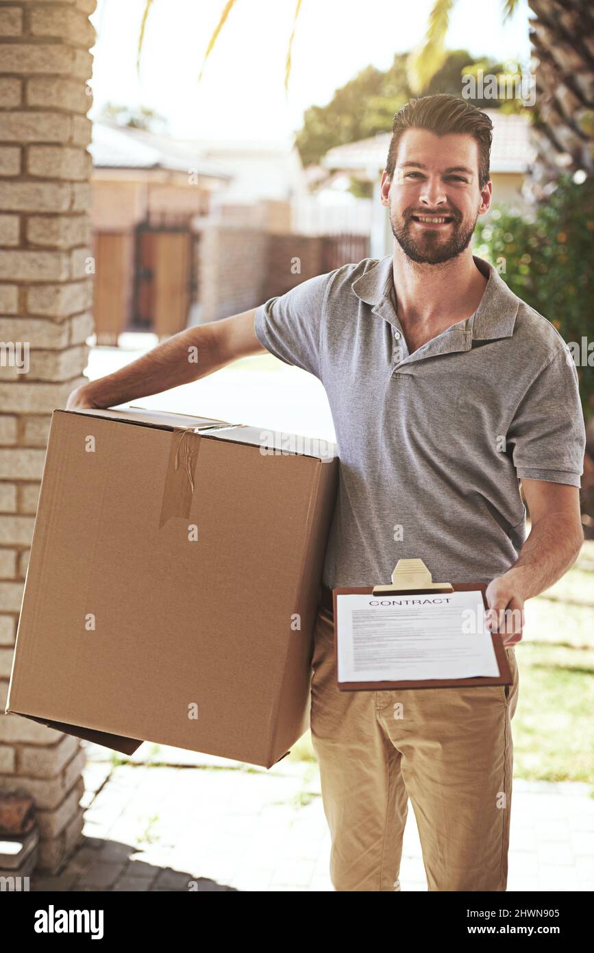 I have a delivery for you. Shot of a young delivery man making a home ...