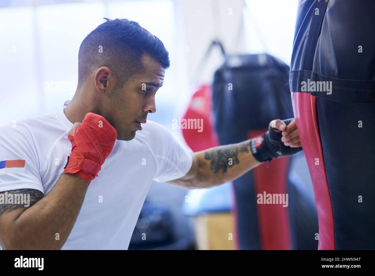 Working on his left hook. Shot of a young man going through his boxing ...