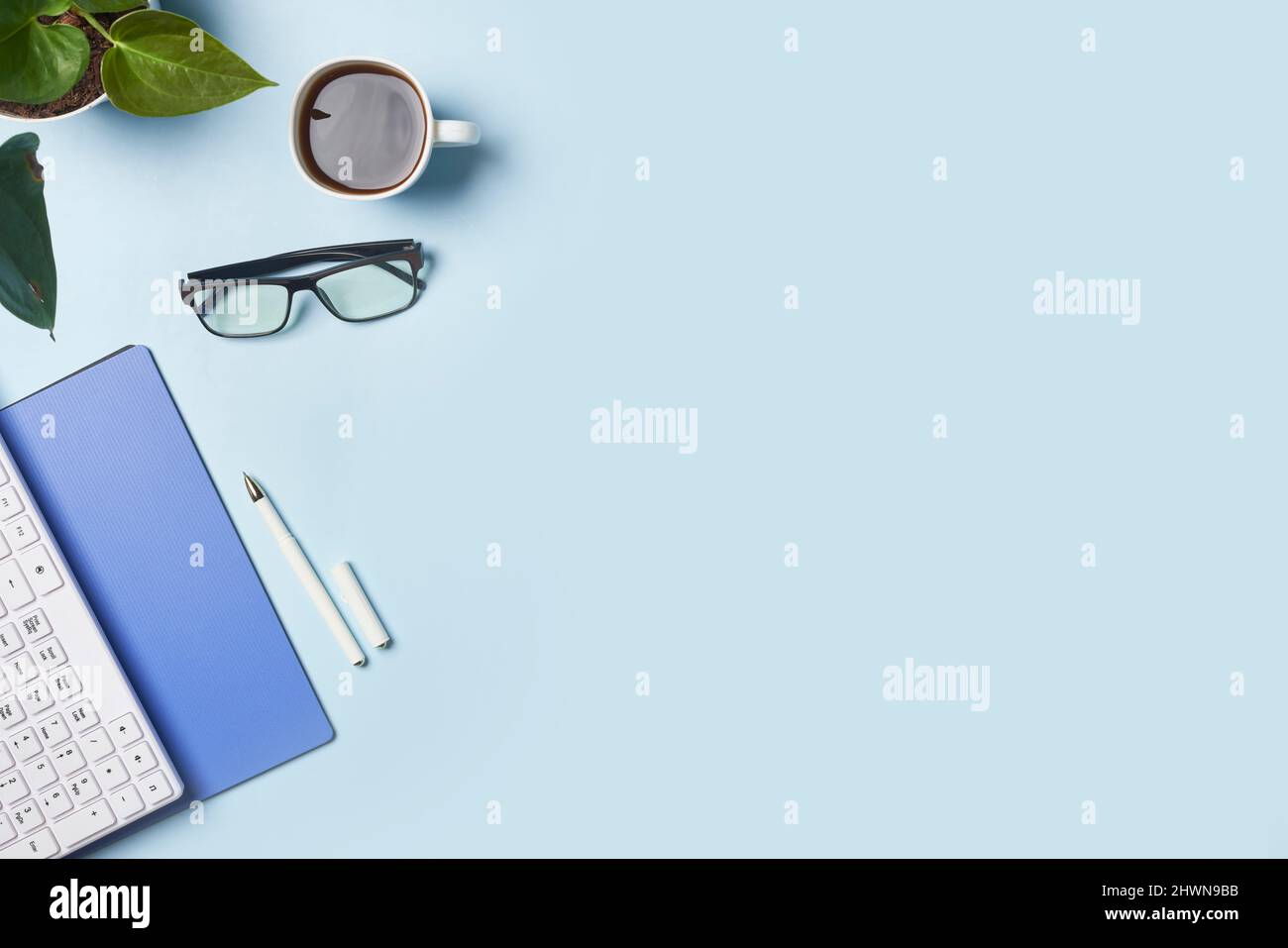 Bright office workspace. Work space with notepad, keyboard, coffee and ...