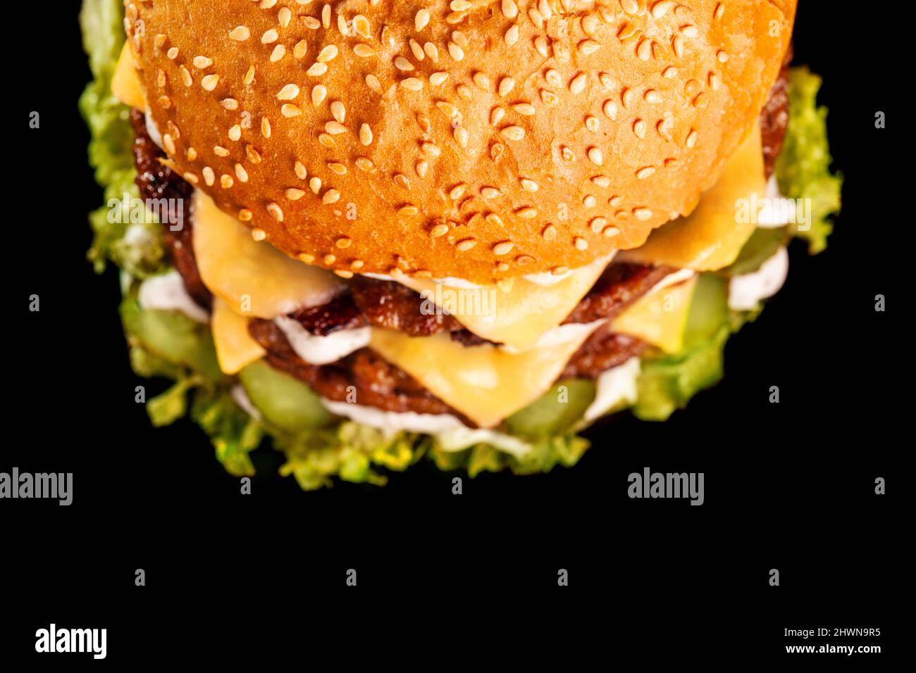 Close up double cheese burger with cucumber and lettuce. View from ...