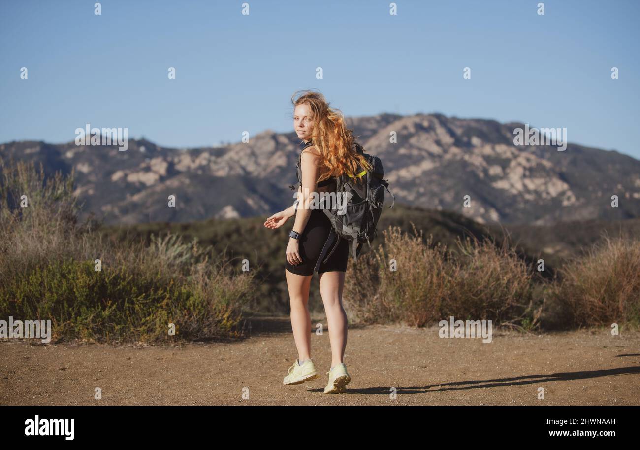 Backpacking tourism concept. Woman hiker with backpack climbed a hill ...