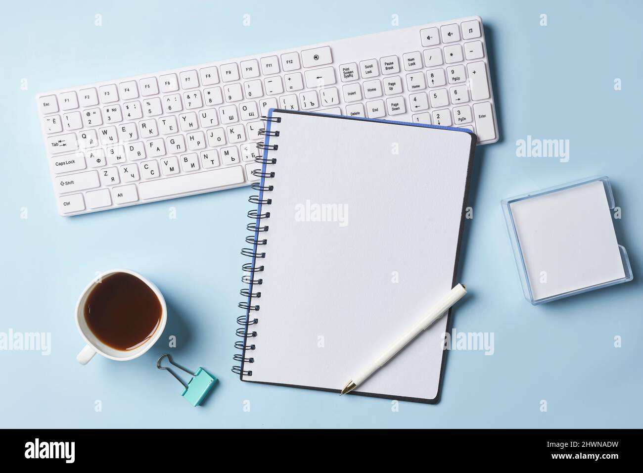 Bright office workspace. Work space with notepad, keyboard, coffee and ...