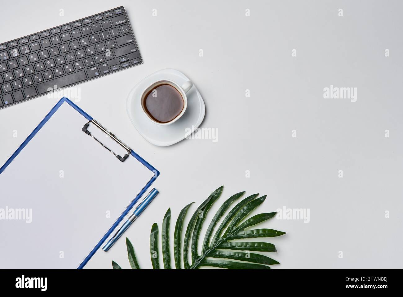 Bright office workspace. Work space with notepad, keyboard, coffee and ...