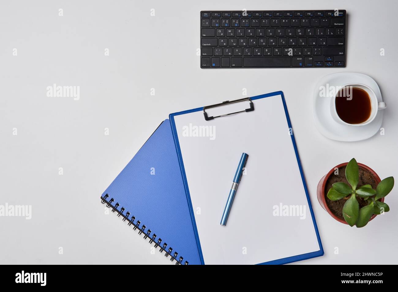 Bright office workspace. Work space with notepad, keyboard, coffee and ...