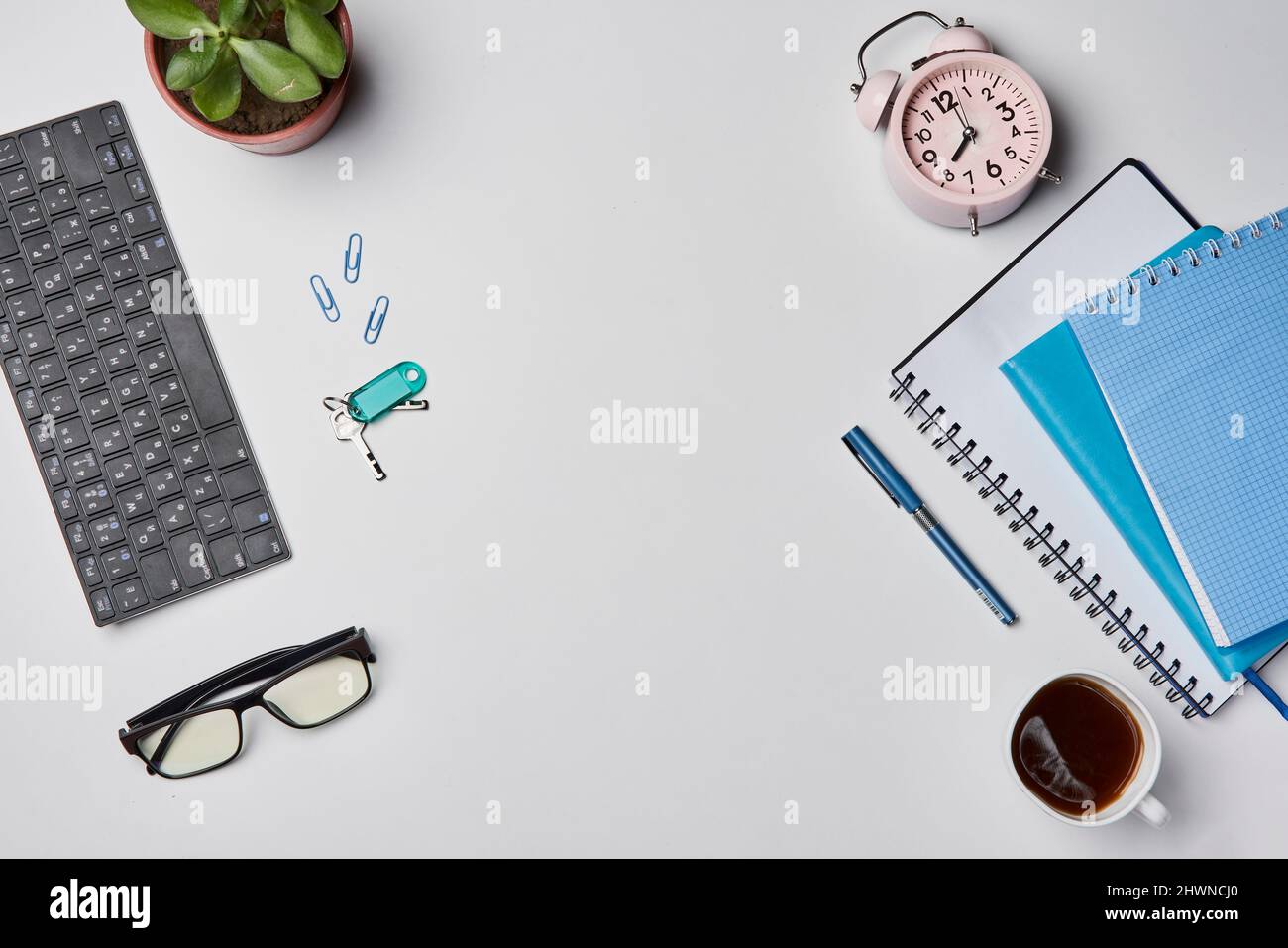 Bright office workspace. Work space with notepad, keyboard, coffee and ...