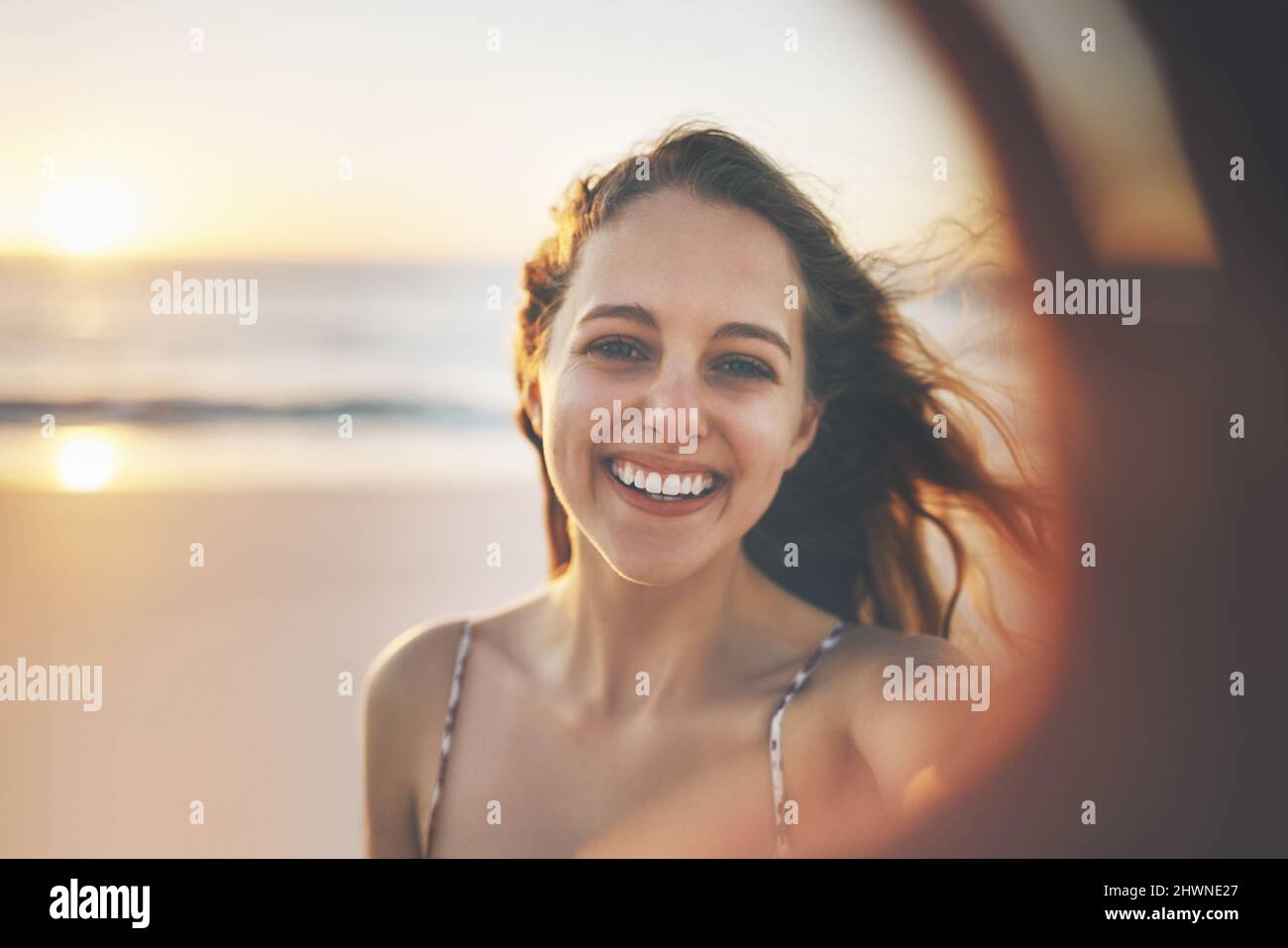 Im all about my beach time. Cropped shot of a young woman enjoying her ...
