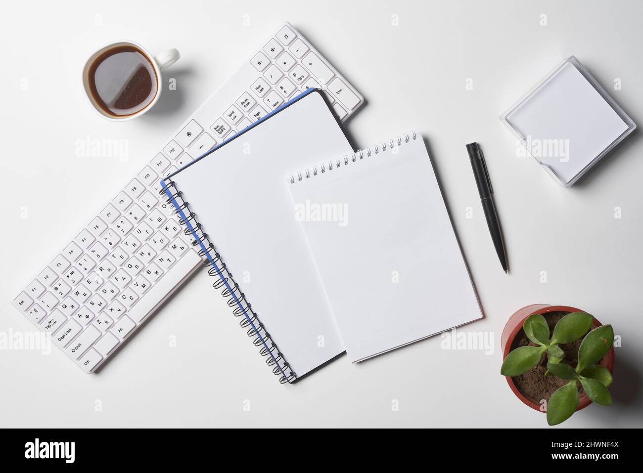 Bright office workspace. Work space with notepad, keyboard, coffee and ...