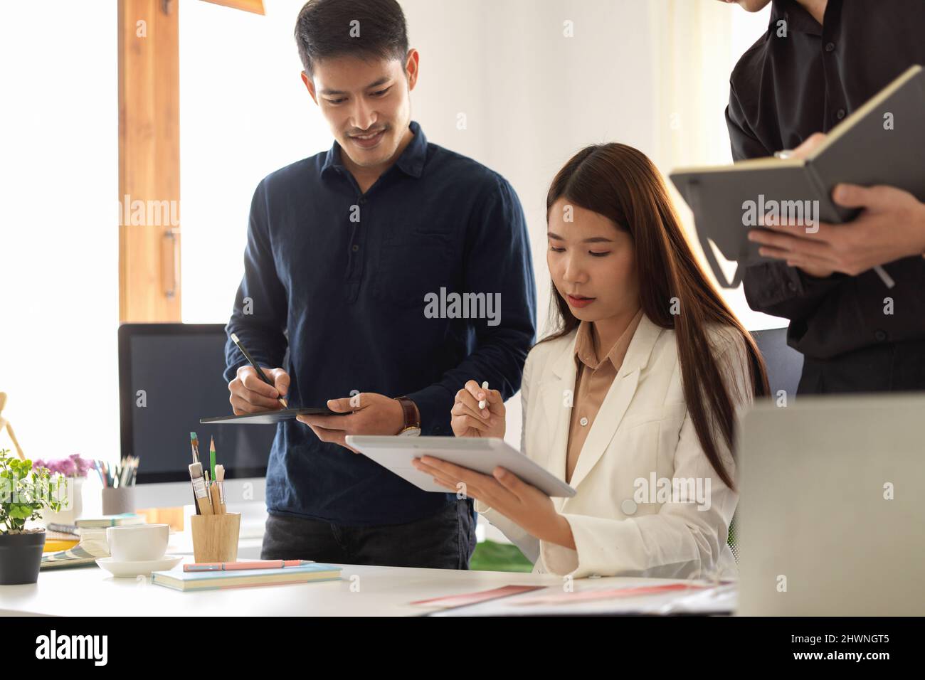 Smart female manager training and coaching two male staff in the office ...