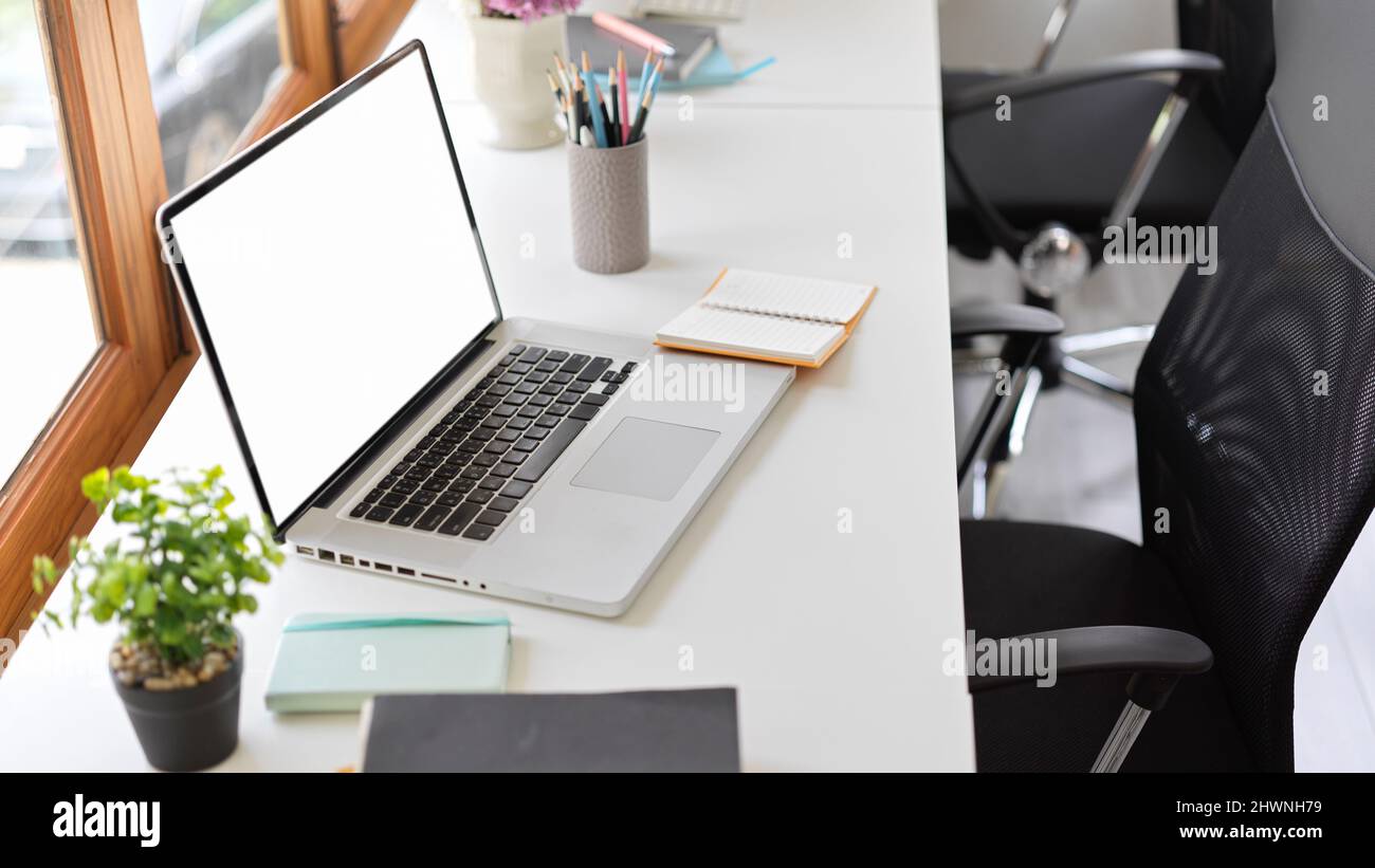Close-up, Office desk with open portable laptop computer white screen ...