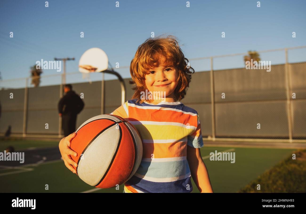 Little caucasian sports kid playing basketball holding ball with happy ...