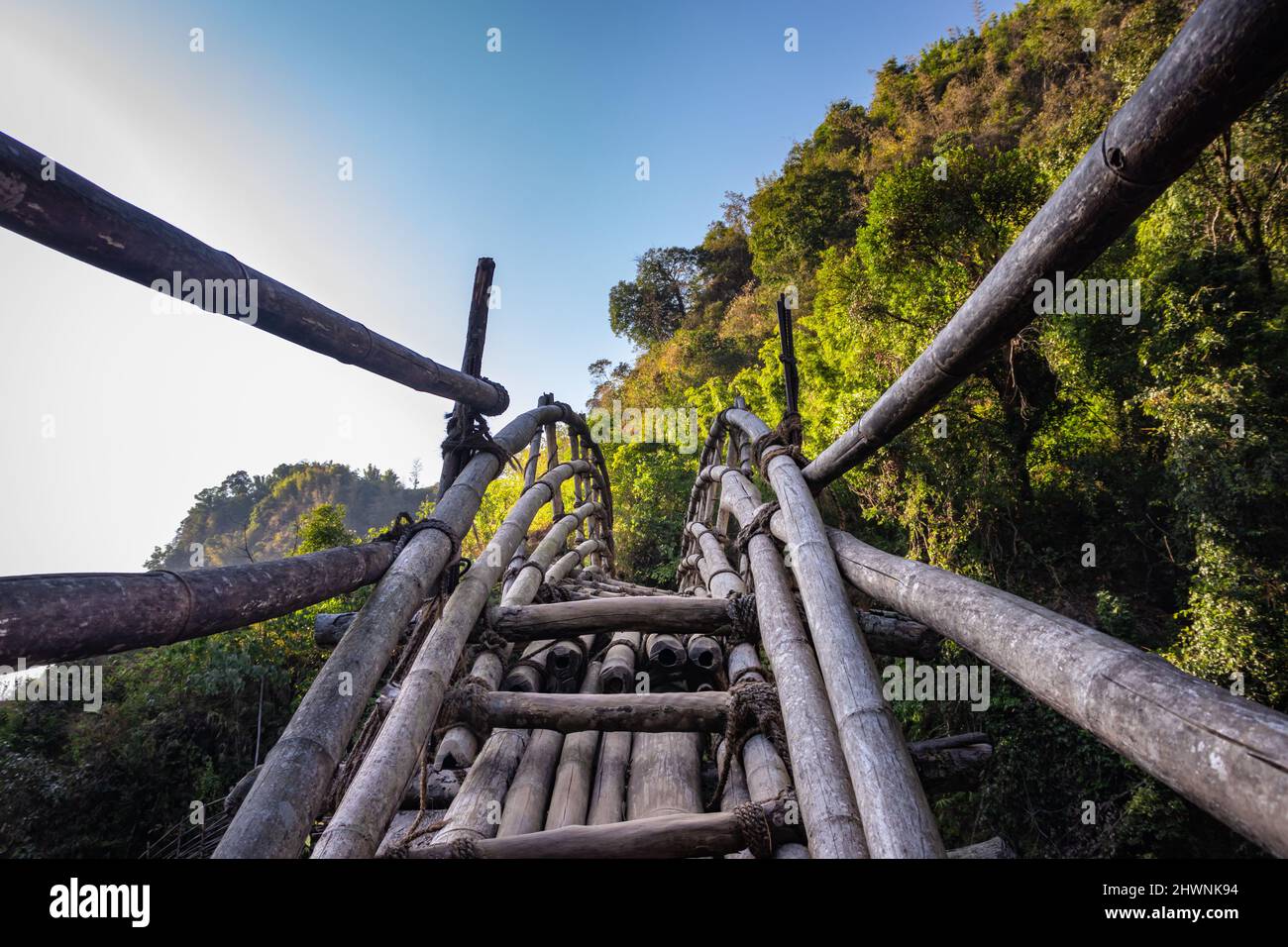 traditional bamboo bridge for crossing river at forest at morning from ...