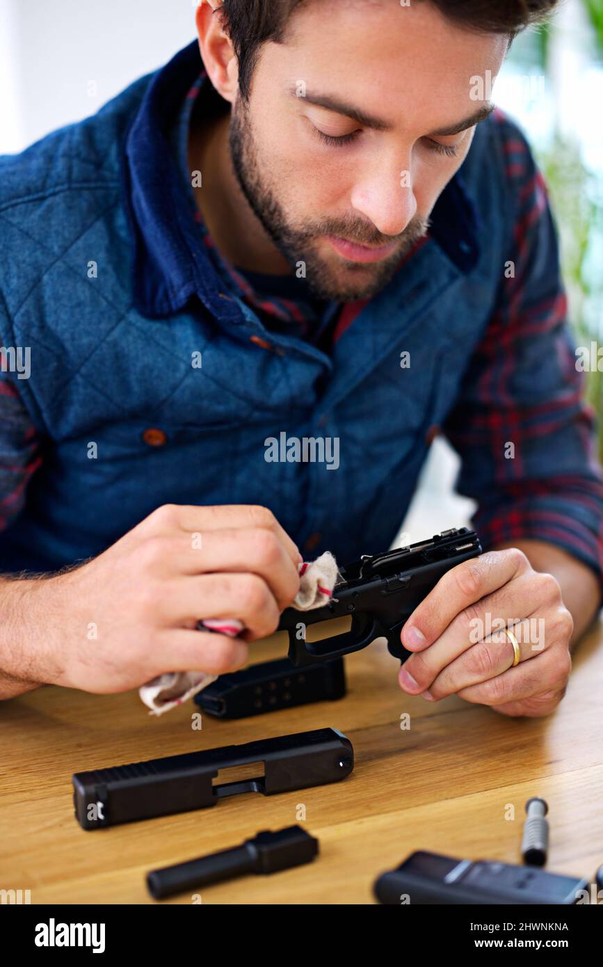 Regular maintenance is essential for every gun owner. A young man ...