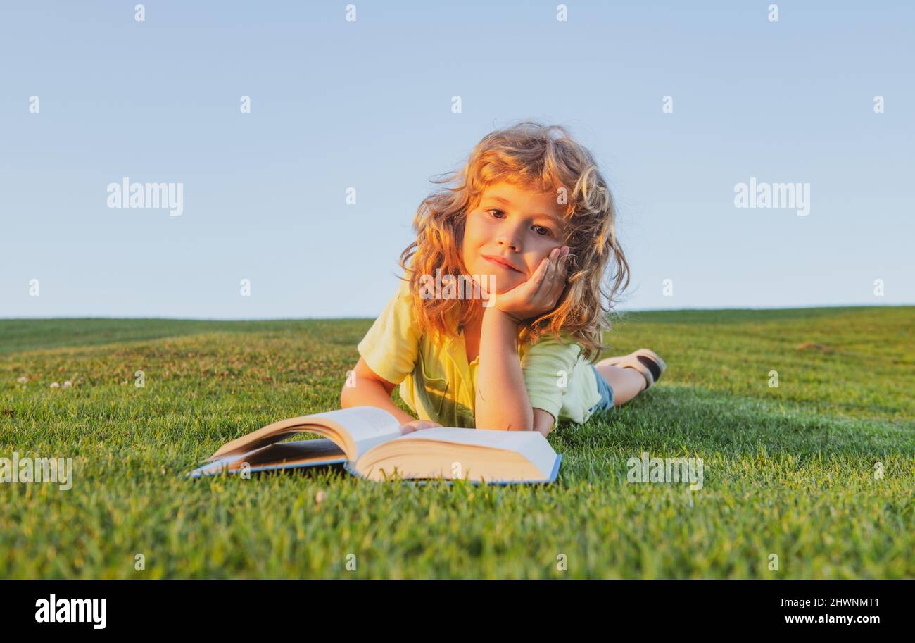 Cute kid reading book outside in summer park on grass Stock Photo - Alamy