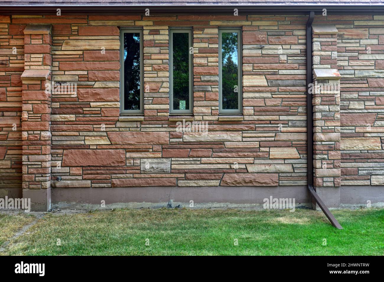 Narrow vertical windows in a modern, exterior sandstone brick wall ...