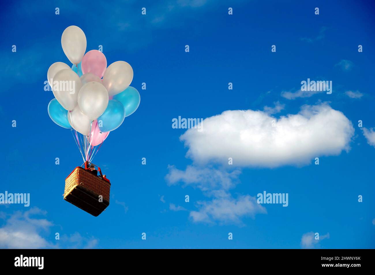 Helium balloons is lifting basket with people Stock Photo - Alamy
