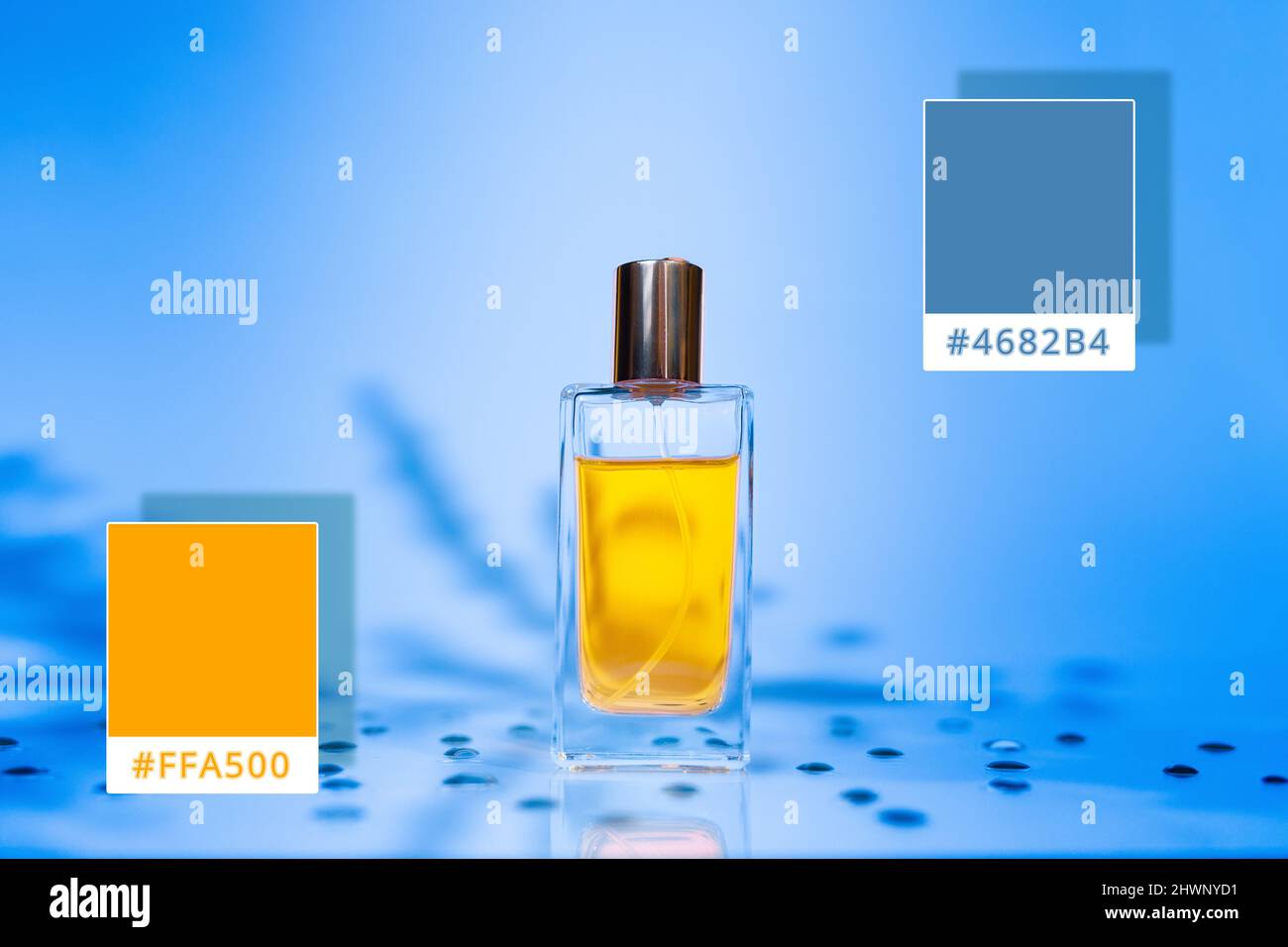 Glass golden perfume bottle on a steelblue background with shadows of ...
