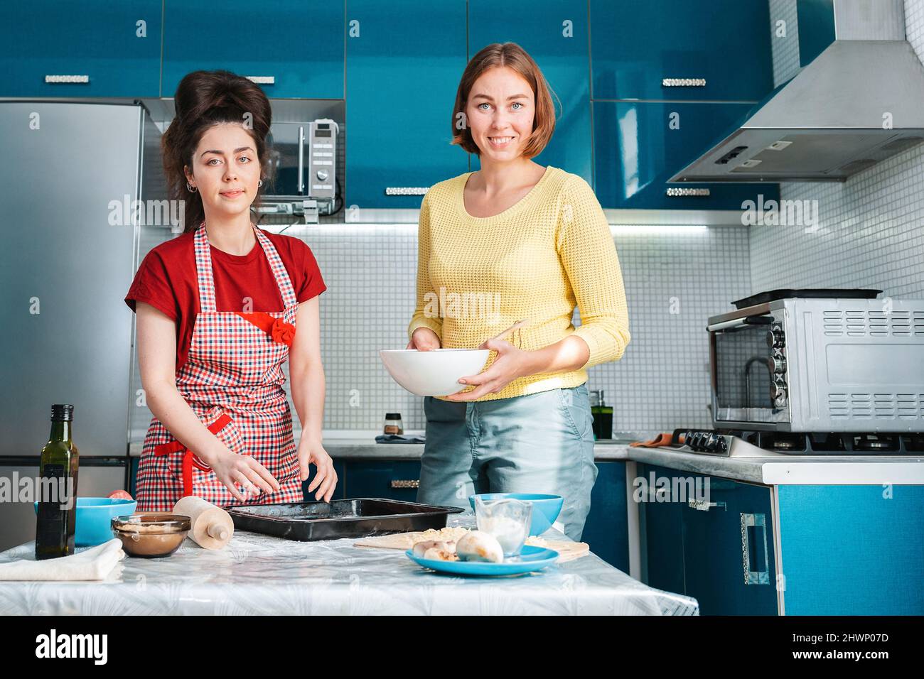 Concept of home-cooked food. Two young pretty caucasian women prepare ...