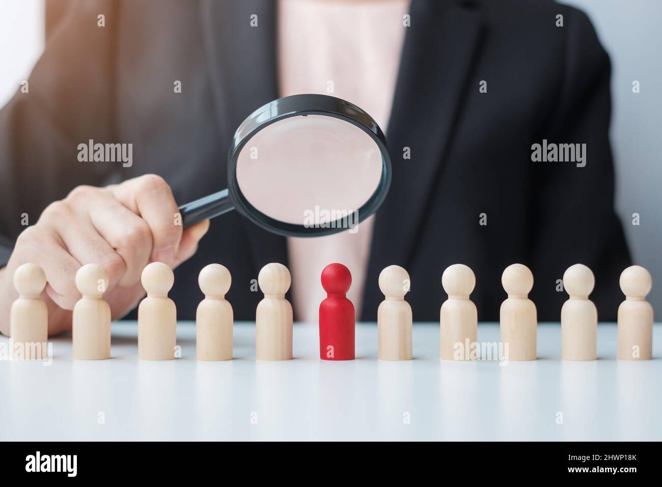 Businesswoman hand holding magnifying glass for recruiting leader man ...