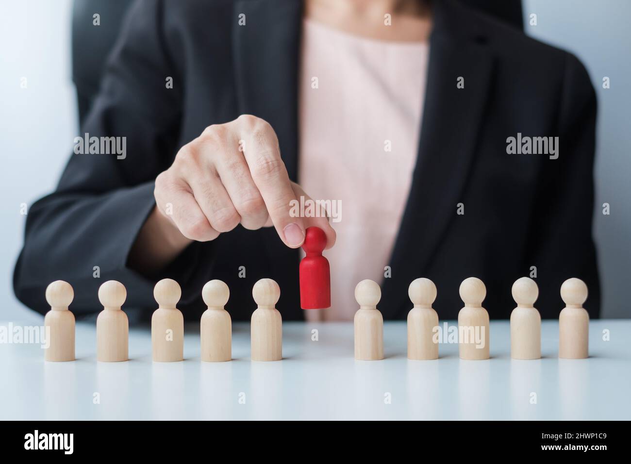 Businesswoman hand pulling leader man wooden from crowd of employees ...