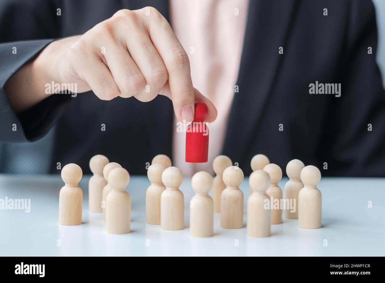 Businesswoman hand pulling leader man wooden from crowd of employees ...