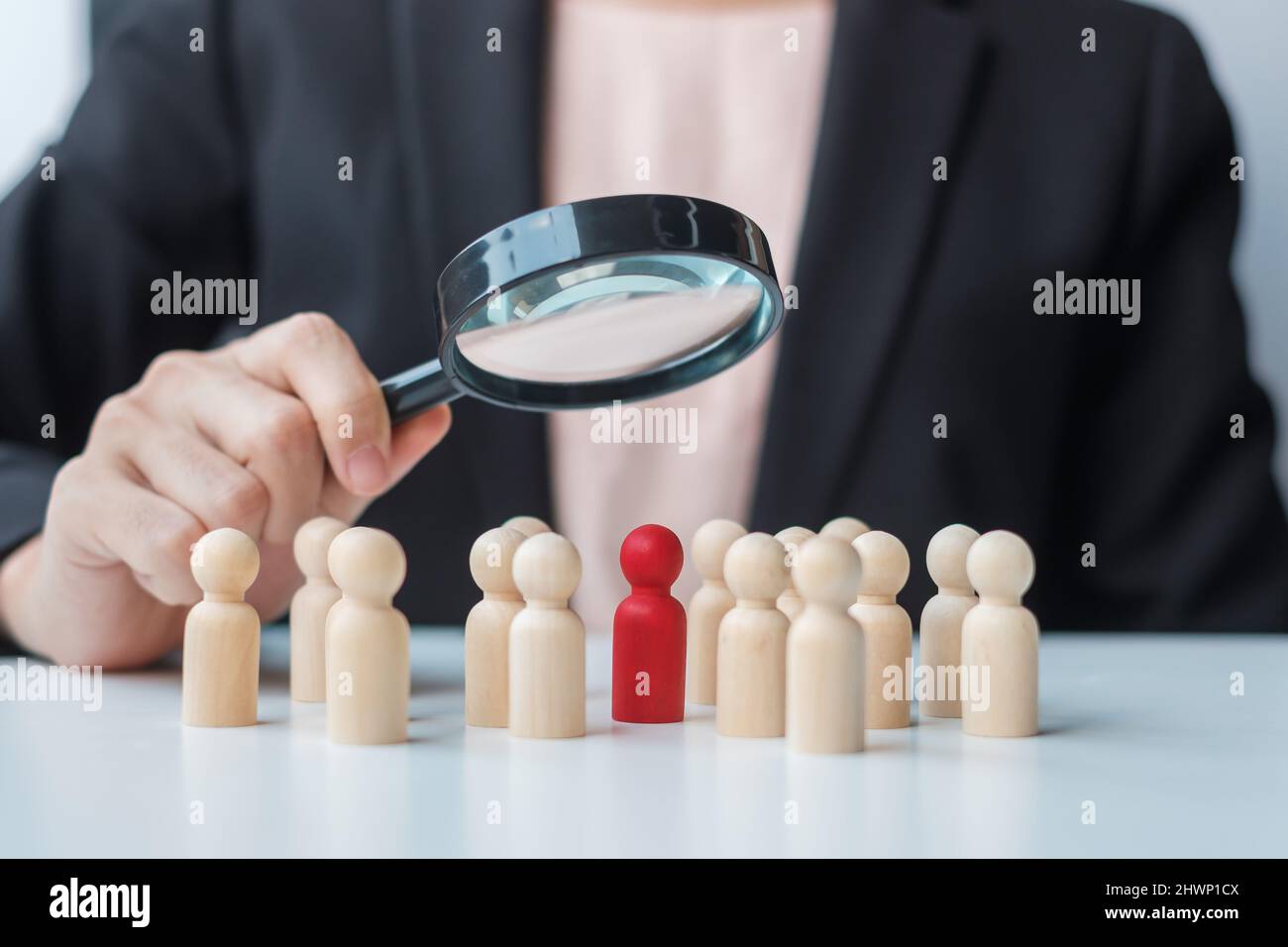 Businesswoman hand holding magnifying glass for recruiting leader man ...