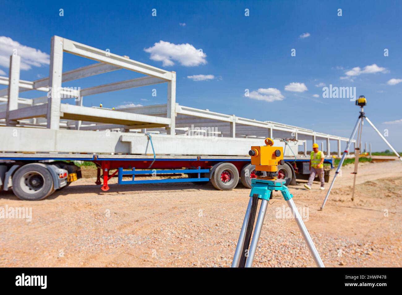 Surveyor instrument is for measuring level on construction site. Truck ...