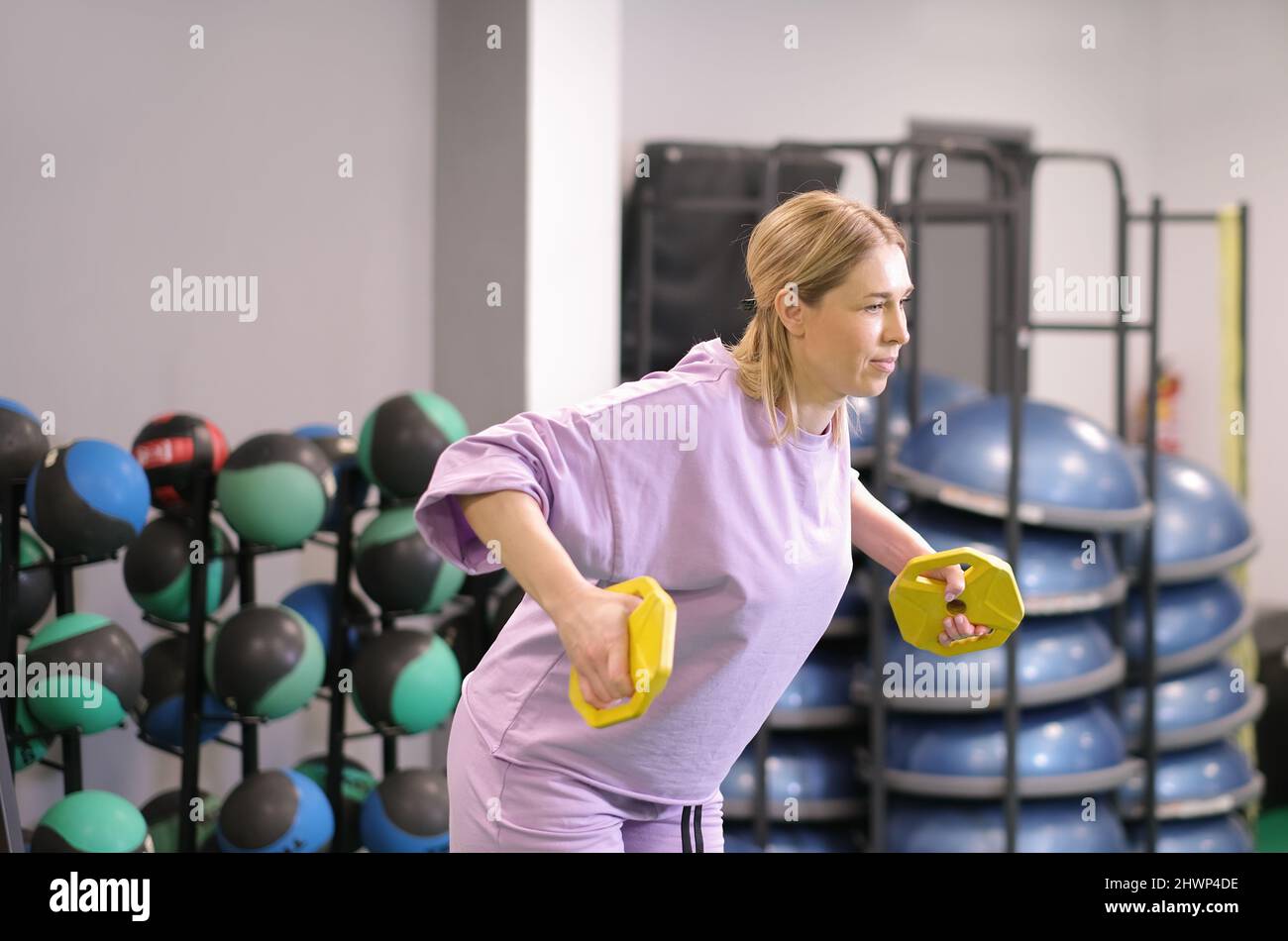 Woman holding a lightweight disks for working out arms and triceps in ...