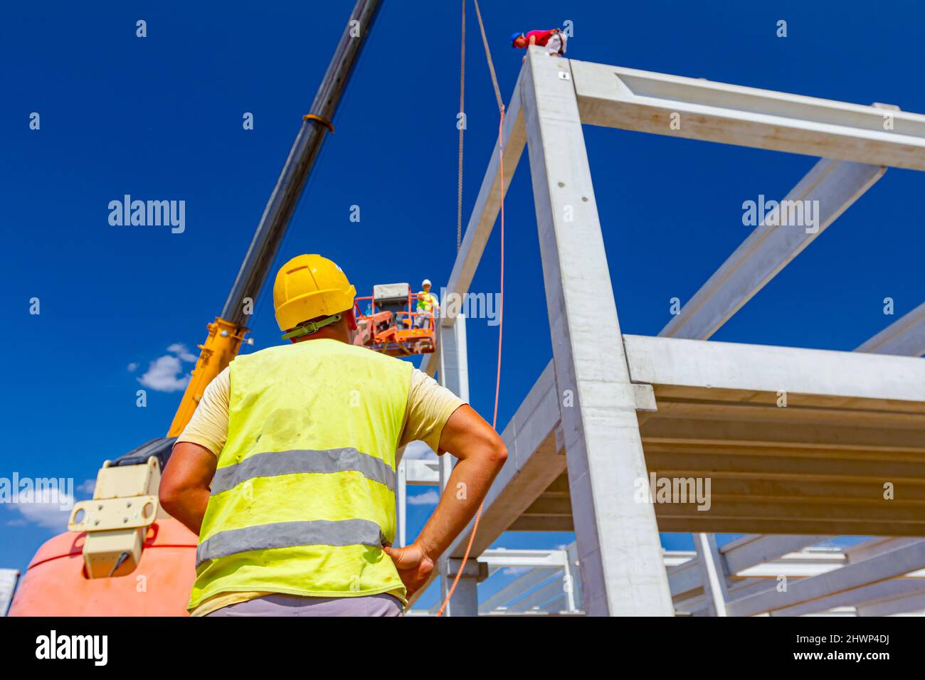 View from behind on construction worker with safety vest and yellow ...