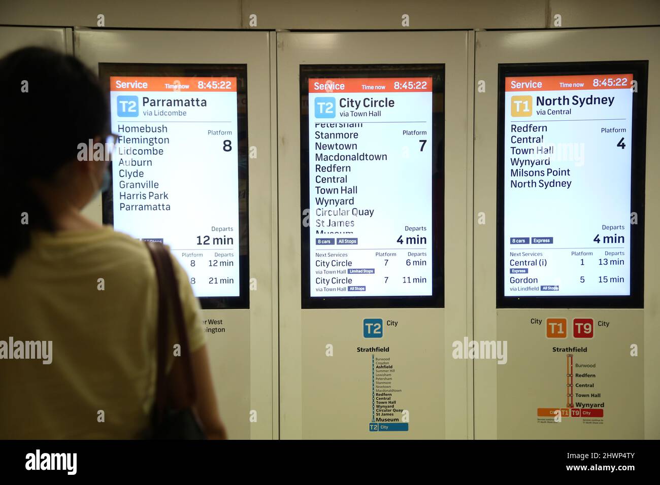 A woman looks at train departure information boards at Strathfield ...