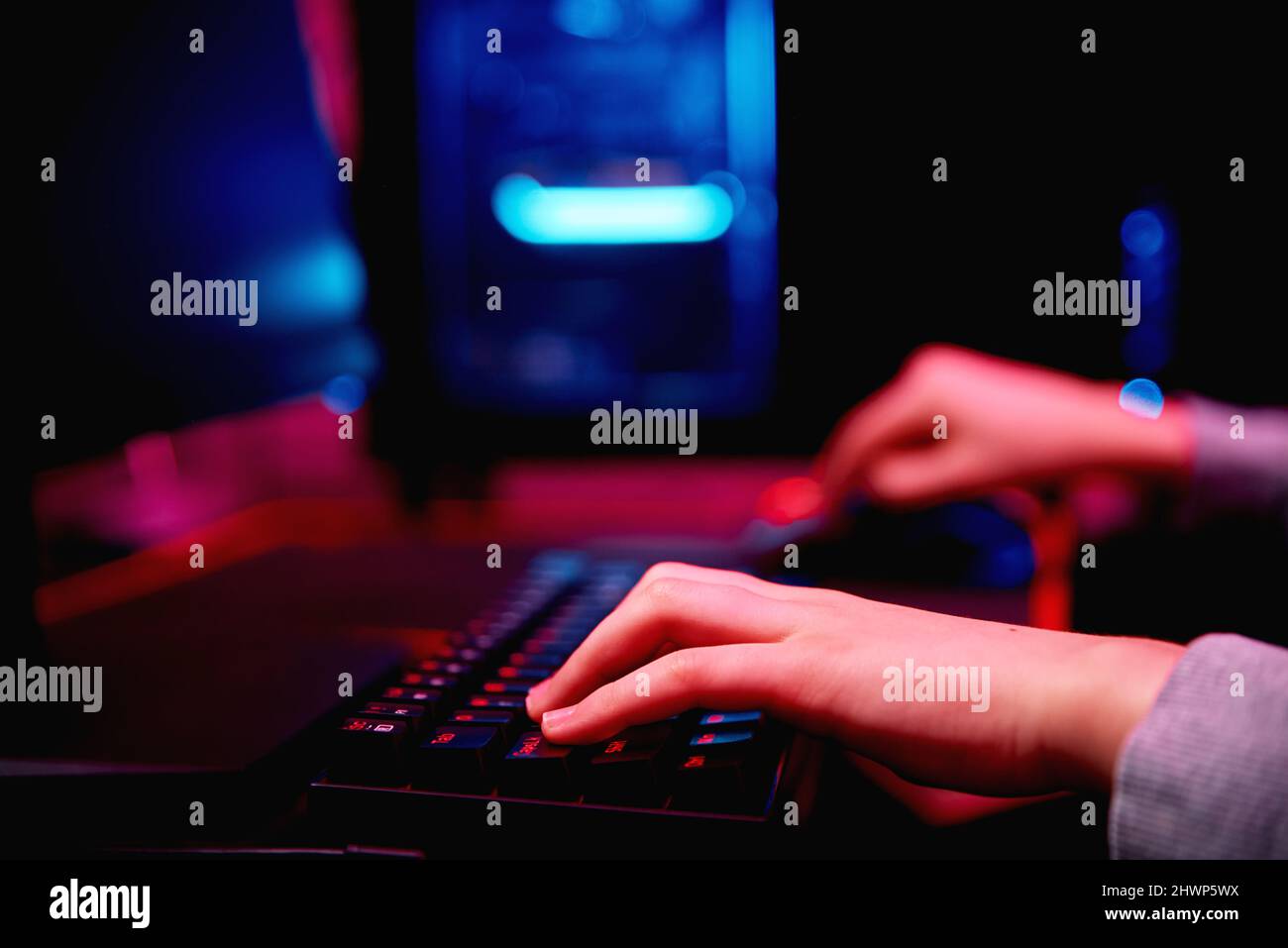 Teenager boy play computer video game in dark room, use neon colored ...