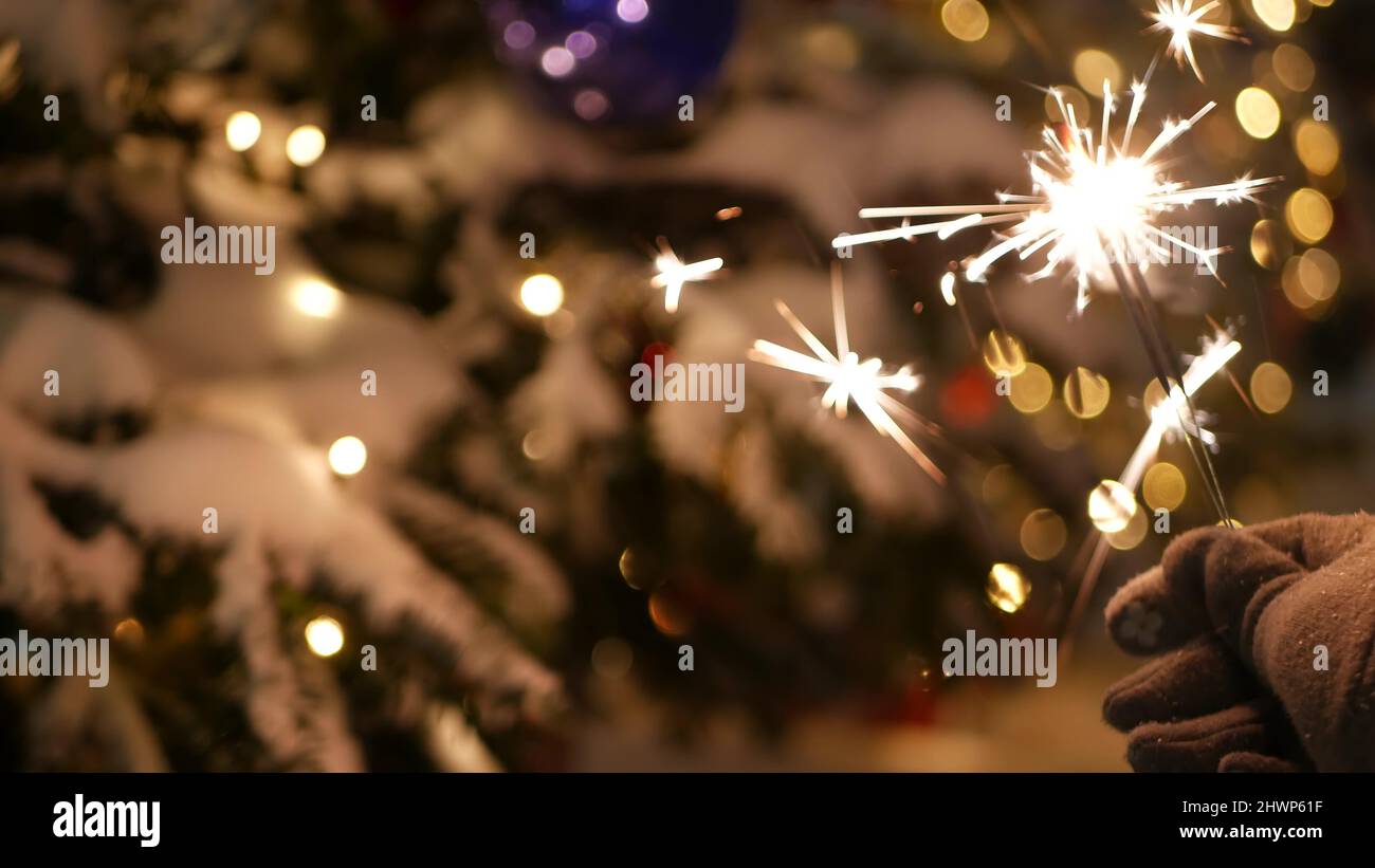 Sparkler firework burning, Christmas tree in snow, New Year or Xmas ...