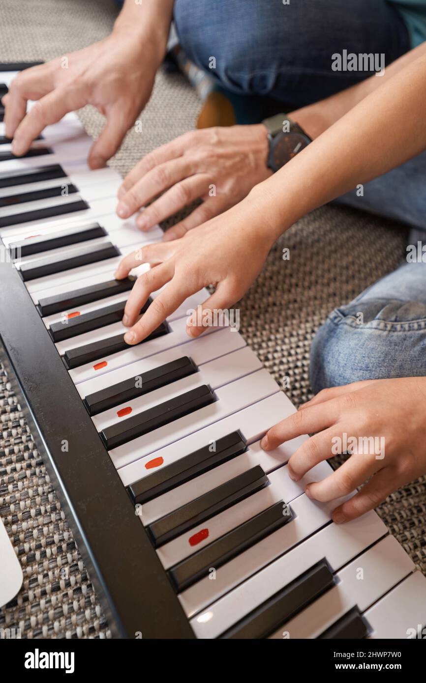 Four hands are playing in electric synthesizer on the floor Stock Photo ...