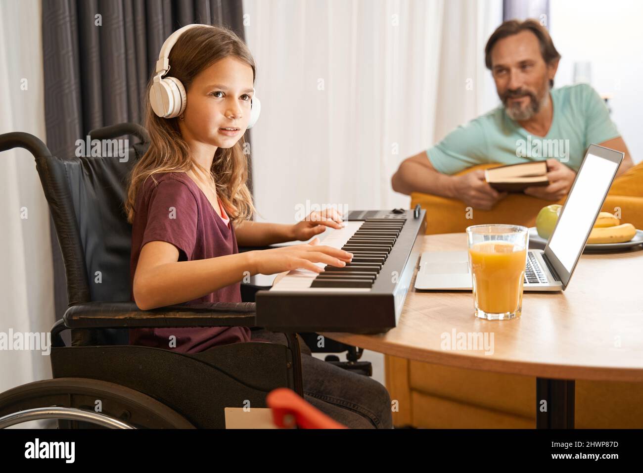 Disabled teenager learning to play the synthesizer with his father ...