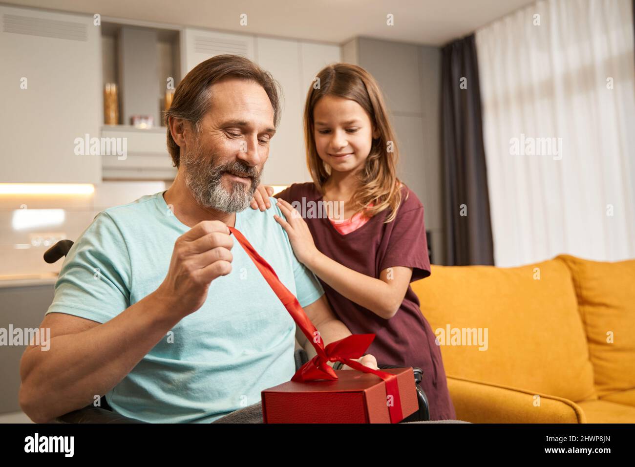 Man in a wheelchair is opening a gift box Stock Photo - Alamy