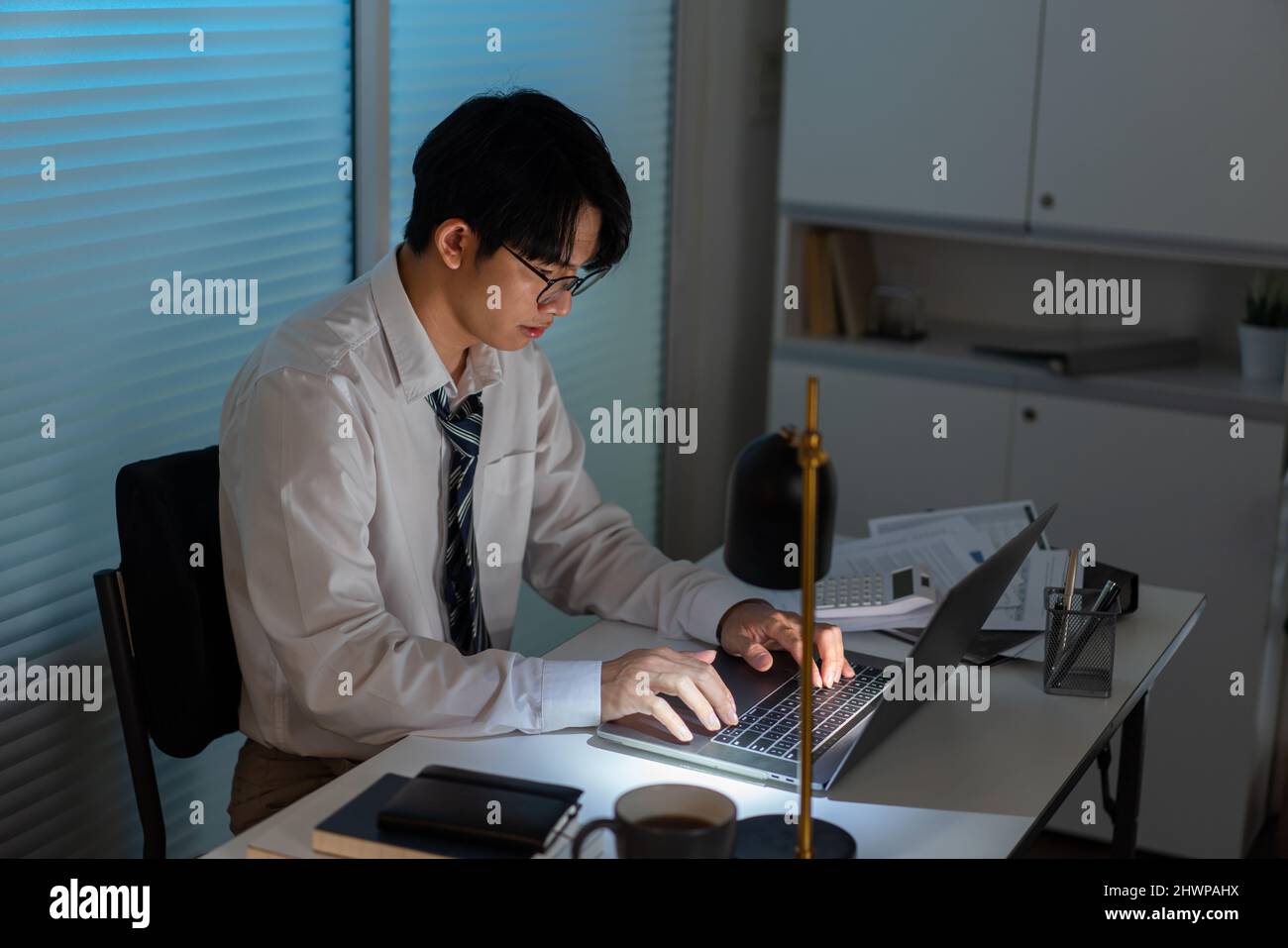 Overwork Concept The man sitting at his desk and focusing on working ...