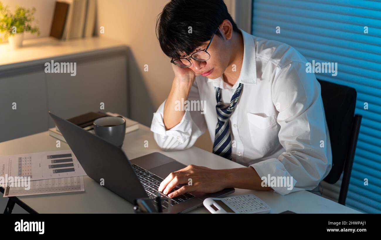 Overwork Concept The man sitting at his desk and focusing on working ...