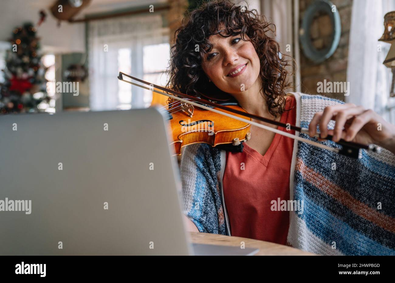 Woman music teacher teaching how to play a song the violin online ...