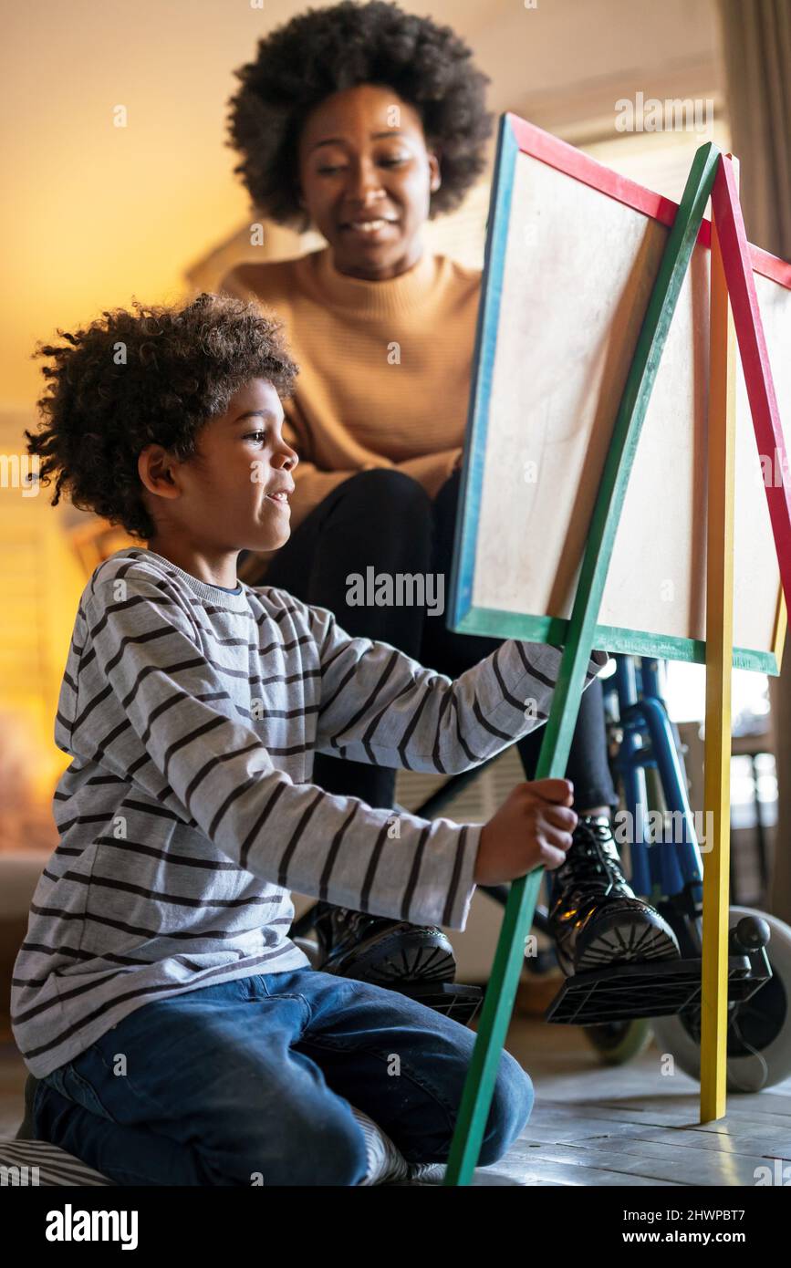 Happy child doing math exercises with her mother ot teacher together ...