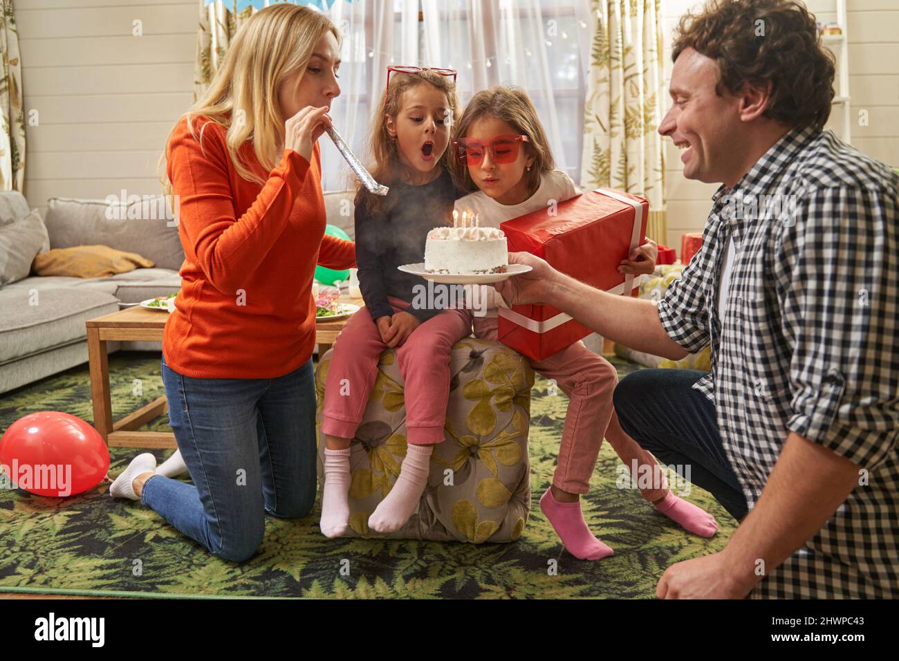 Young girls having birthday party with parents Stock Photo - Alamy