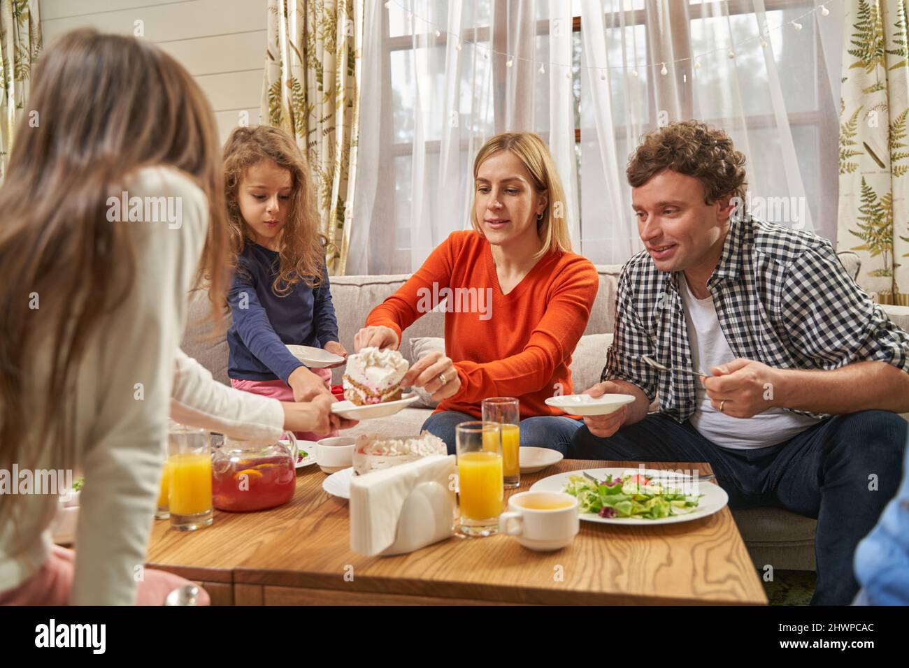 Portrait of parents with children eating at home Stock Photo - Alamy