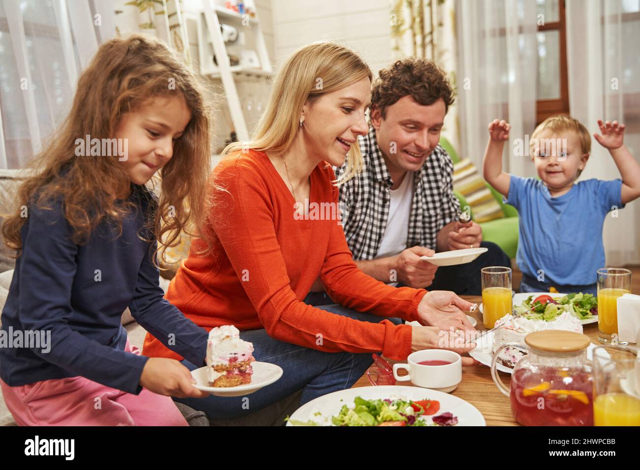 Parents with daughter and son eating at home Stock Photo - Alamy