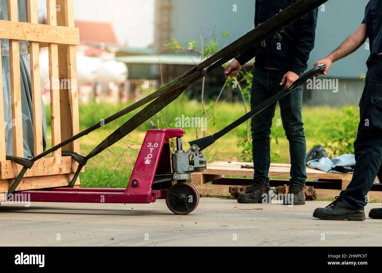 Worker working with hand pallet forklift stacker to delivery machine in ...